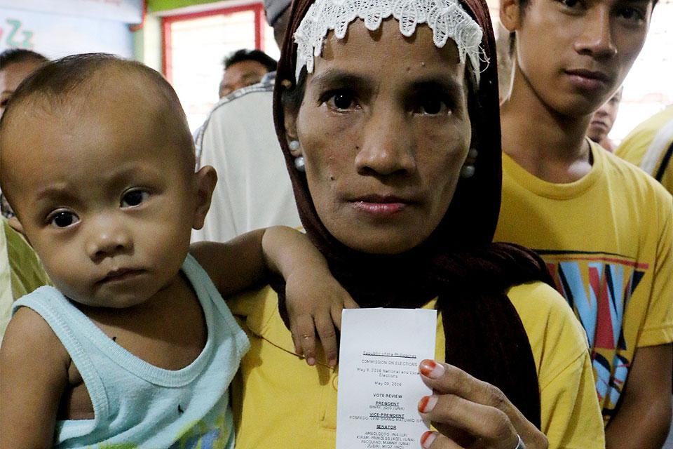 Voter shows VCM receipt after casting vote in Cotabato City | Photos ...