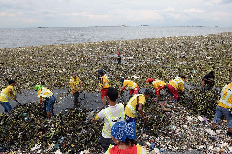 Garbage washed ashore by Carina's strong waves fills parts of Manila ...