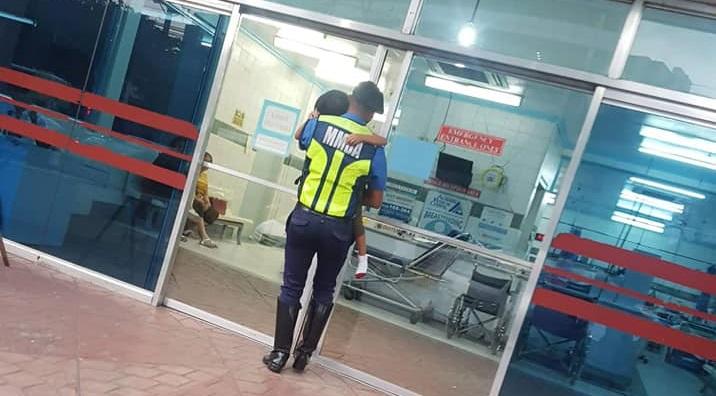 MMDA enforcer carries sick child stuck in traffic to the nearest ...