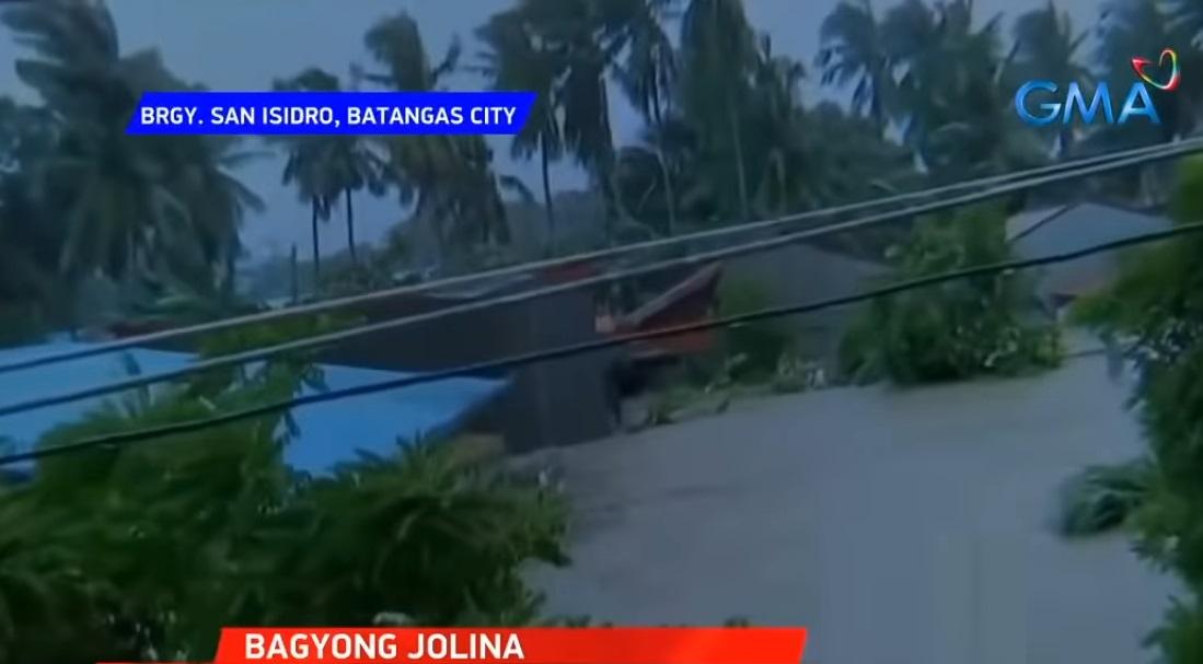 Families in Batangas barangay climb up roofs to escape floods | GMA ...