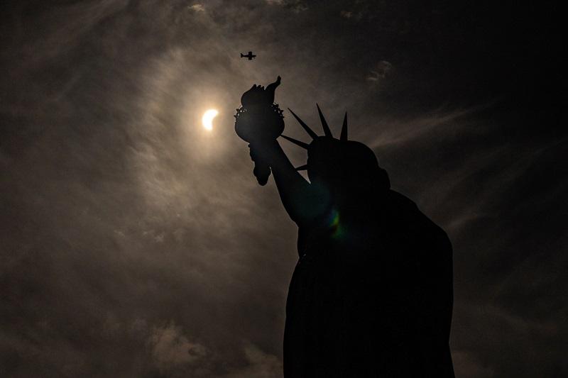 Statue of Liberty is seen during a partial solar eclipse | Photos | GMA ...