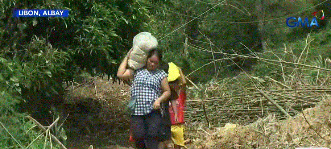 Residents walk in mud to get supplies as landslides blocked roads in ...