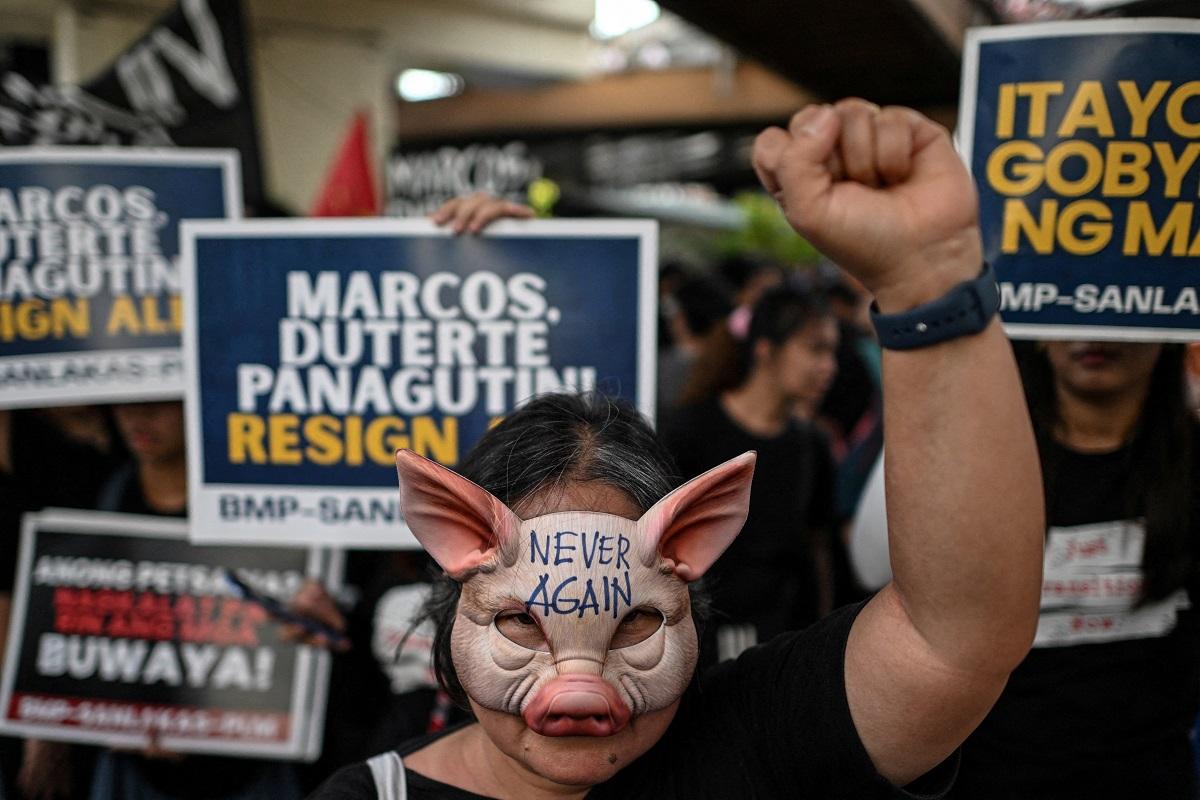 ‘Never again,’ protester’s mask says at People Power Revolution’s 40th ...